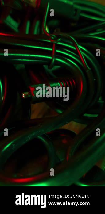 Optical cable among tangled black cables lit with red and green ...