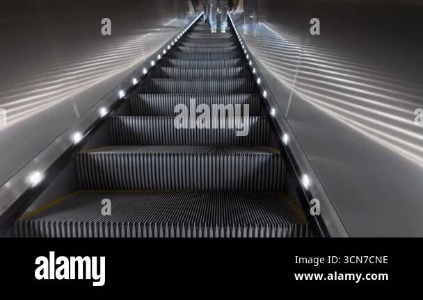 People riding up an escalator in a modern urban space concept of ...