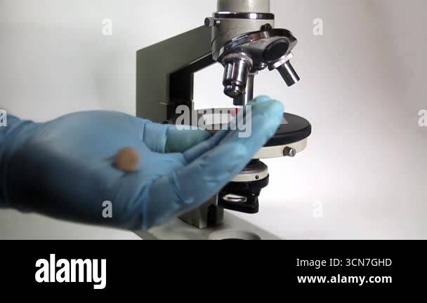 A male doctor's hand in a blue glove catches many multi-colored pills ...