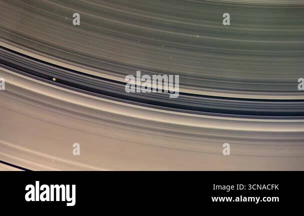 A detailed view of Saturn's magnificent rings with an orbiting moon ...