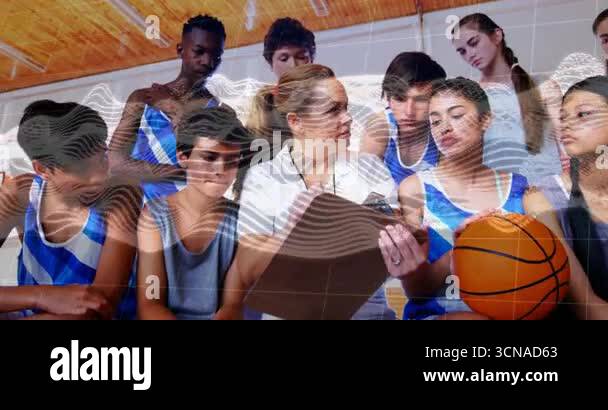 Coach flipping clipboard page instructing youth basketball players with ...