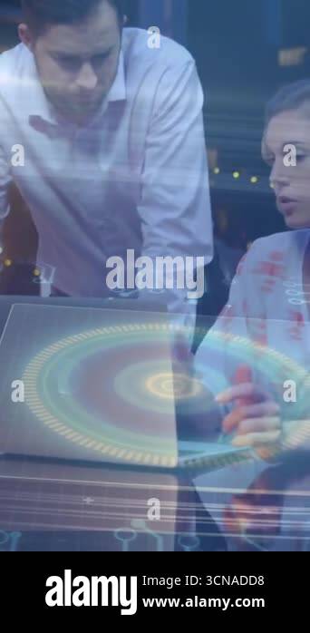 Collaborating in office, colleagues using laptop with animation on ...