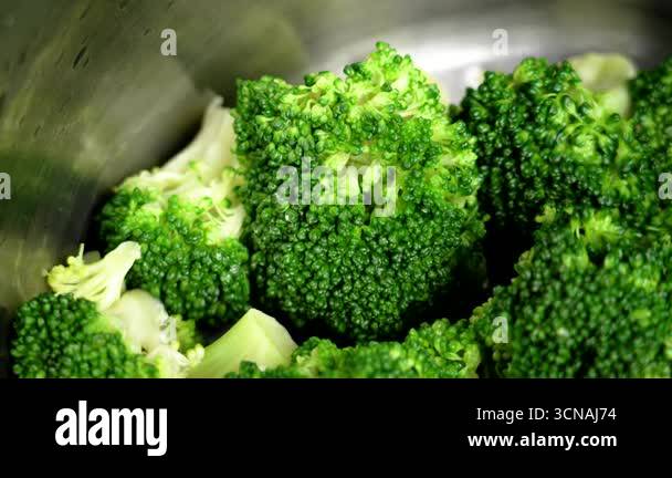 Steamed broccoli in stainless steel saucepan. Healthy dietary cooked ...