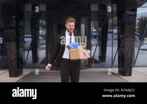 A visibly sad man reacts to job loss outside a corporate building ...