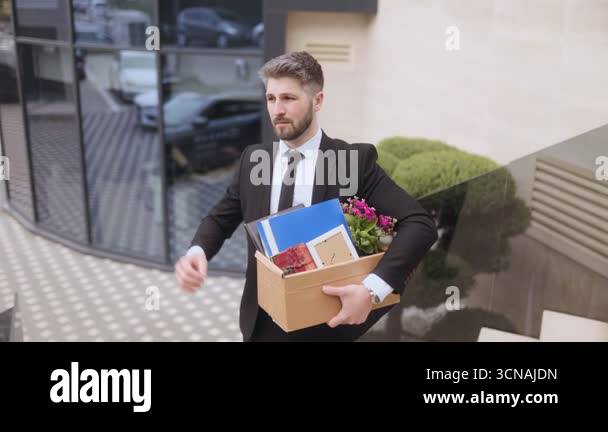 Emotionally devastated man stands outside a corporate building after ...