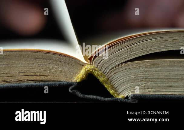 Page of an old book being turned over by a man's hand, close up ...