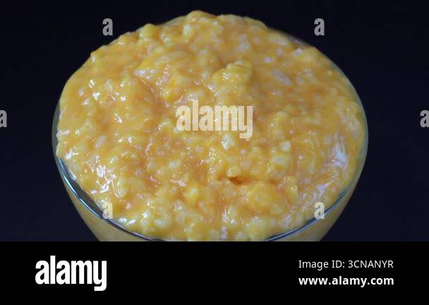 Pumpkin porridge with rice, milk, vanilla and sugar in a plate rotates ...