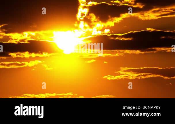 A dramatic timelapse captures the bright golden sun setting behind dark ...