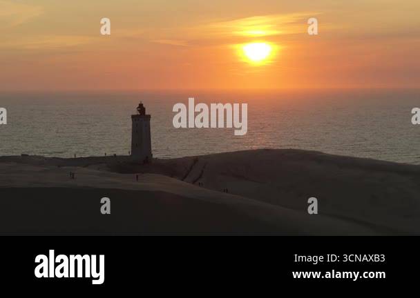 Aerial view of the giant sand dunes with the famous lighthouse on the top of a hill. Rubjerg ...