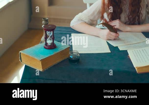 Medieval red-haired woman writer holds pen feather quill in hands close ...
