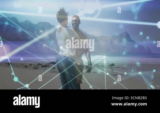 Male dancer lifting arms guiding partner spinning on beach, technology ...