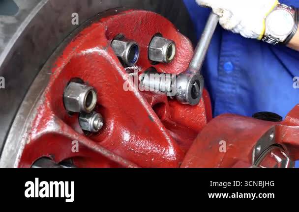 Close-up shot of a mechanic's hands using a socket wrench or ratchet ...