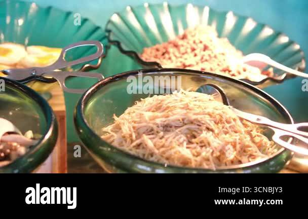 Serving spaghetti from a hot tray with other buffet dishes including ...