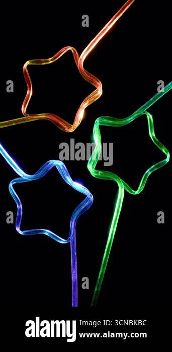 Vibrant liquid flowing through star-shaped straws in blue, orange, and ...
