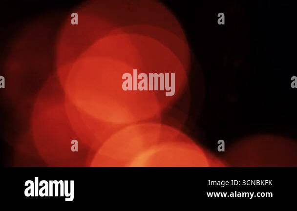 Warm, glowing bokeh circles drift over a black background, creating a ...