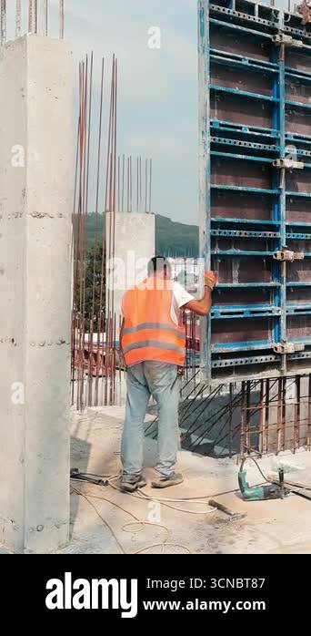 Builders install a large metal structure for pouring monolith. Construction work at the ...