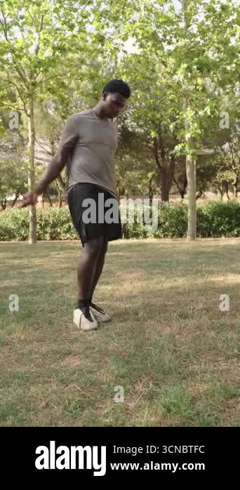 Slow motion sequence of an athlete jumping rope in a park, showcasing ...