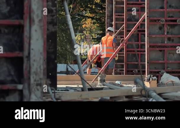 Construction Workers Installing Wall Formwork, Team In Safety Vests ...