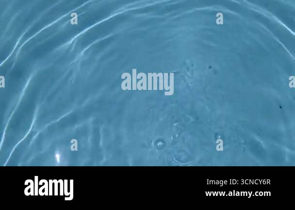 Realtime video 4k. Close-up clear light blue water with gentle ripples ...