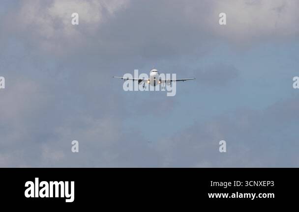 Wide shot of a passenger airplane descending in the sky on final ...