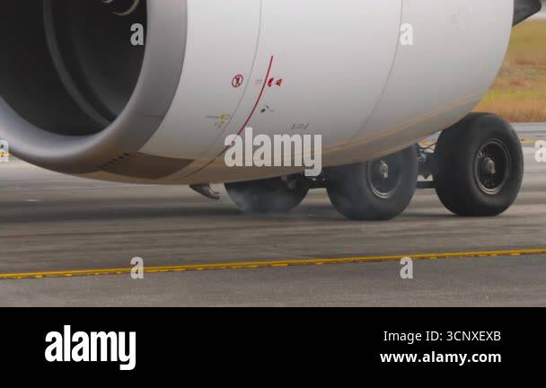 Close-up of aircraft engine and landing gear while parked on the apron ...
