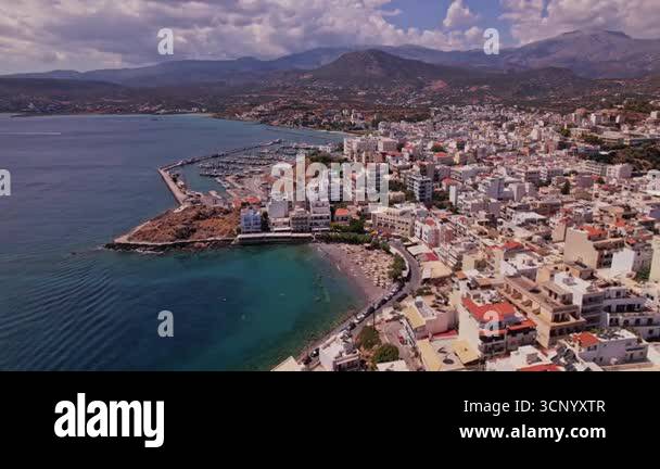 A breathtaking view showcases a coastal town in Crete with vibrant ...