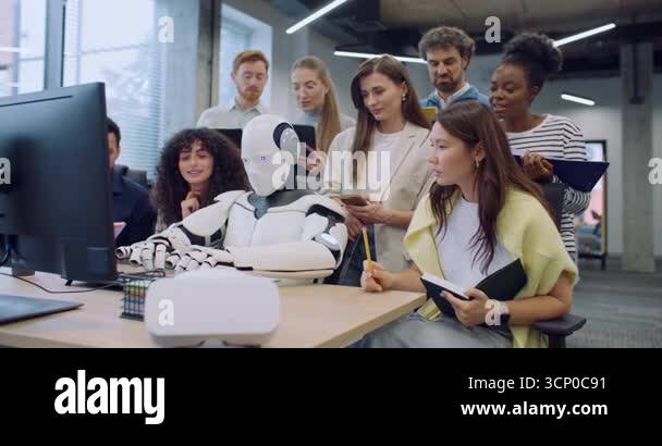 Group of multi-ethnic students surrounding robot. Humanoid sitting at ...