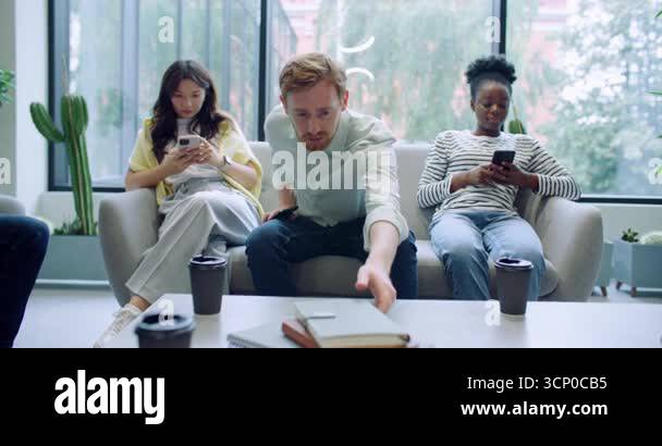Camera moving closer to multi-ethnic group of strangers sitting on grey ...