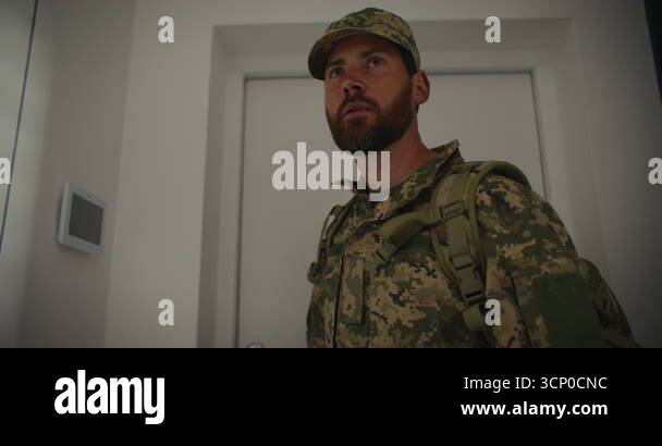 View from below of happy Caucasian soldier opening door and entering ...