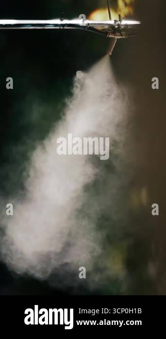 A jet of water spraying into the air against a dark background Stock ...