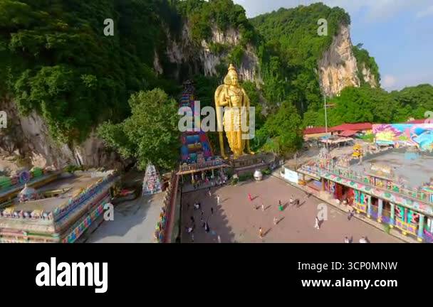 Cinematic FPV drone shot of golden Murugan statue at Batu Caves in ...