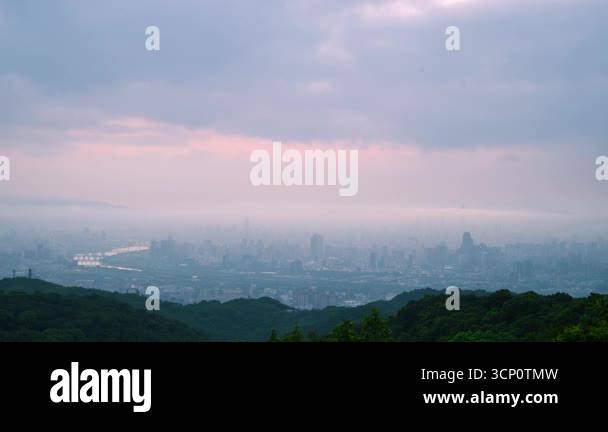 Aerial footage of Taipei City skyline shrouded in orange mist at dawn ...
