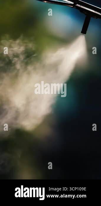 A jet of water spraying into the air against a dark background Stock ...
