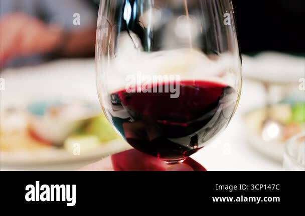 Close up of a glass of red wine being swirled showcasing the rich ruby ...