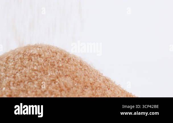 brown sugar, crystals granulated organic sugar pouring onto pile ...