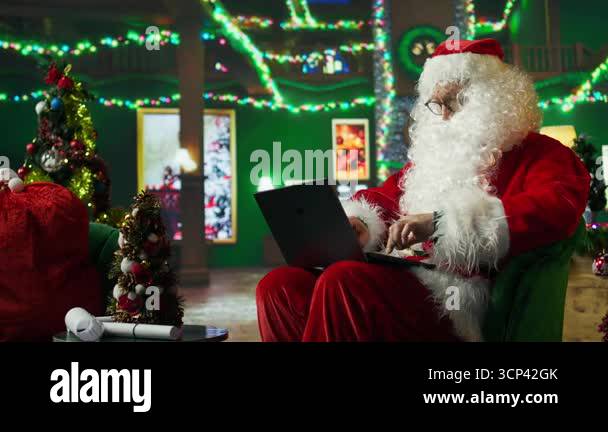 Santa Claus performer typing on laptop, preparing shipping parcel with ...