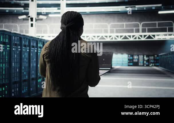 Engineer in server hub using laptop to upgrade rigs for increase in workload capacity using AI ...