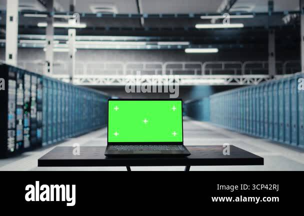 Green screen laptop in high tech data center facility with multiple rows of fully operational ...