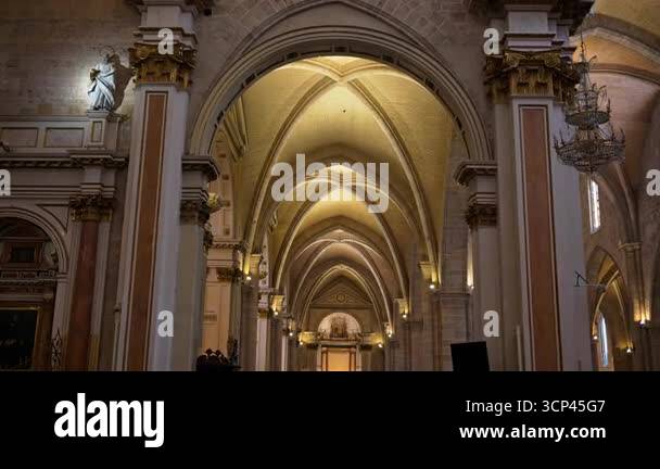 Symmetrical interior view down a Gothic nave with ribbed vaults and ornate columns in the ...