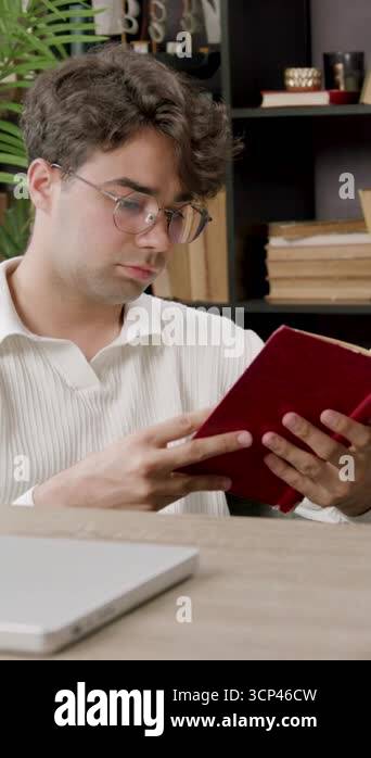 Serious student reading a book and looking for ideas for a project for ...