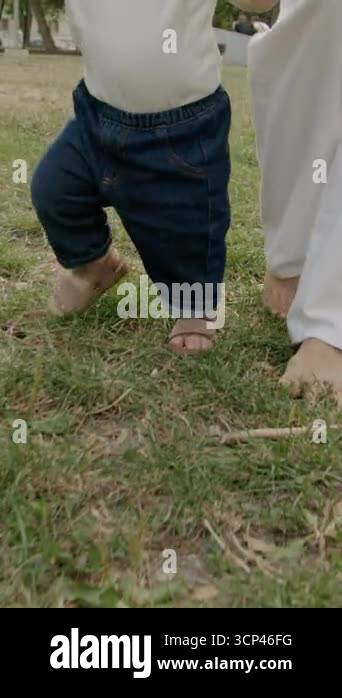 Baby engages with grass and leaves, exploring textures and colors in a ...