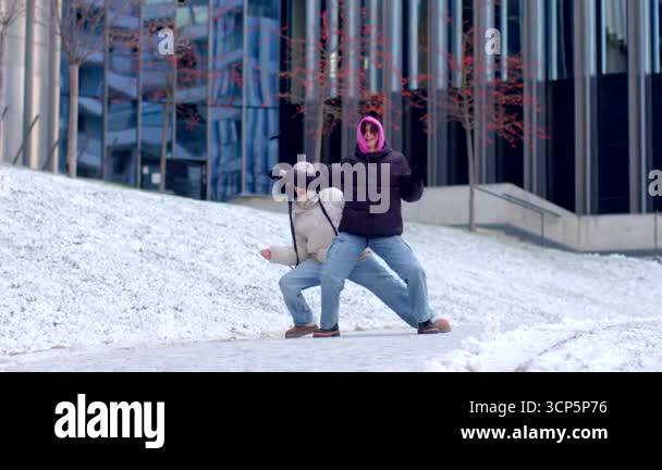 In a winter wonderland, a couple has fun in the snow, dancing joyfully ...