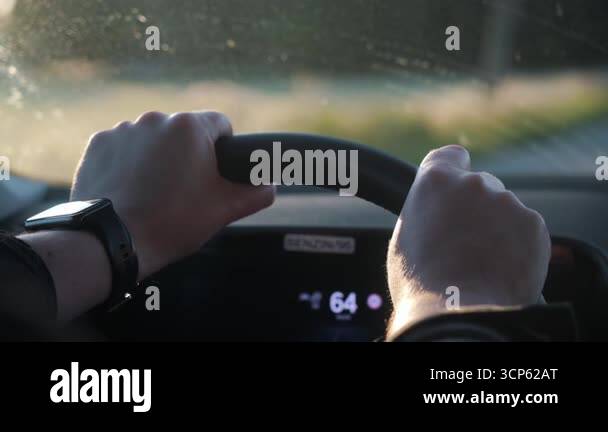 A closeup view of hands firmly gripping the steering wheel while ...