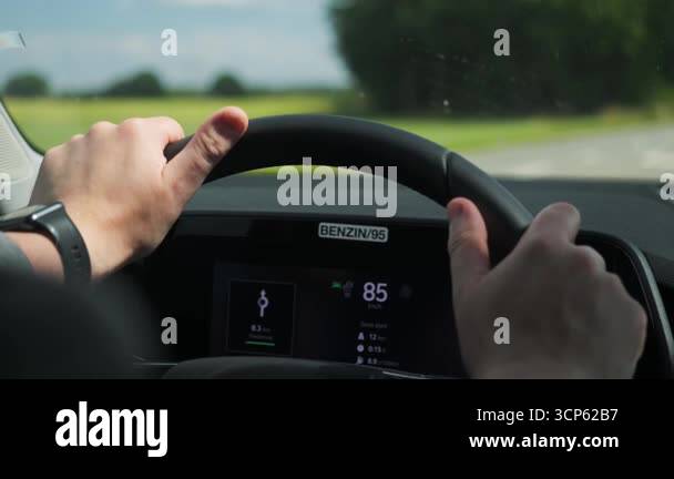 A closeup view of hands firmly gripping the steering wheel while ...