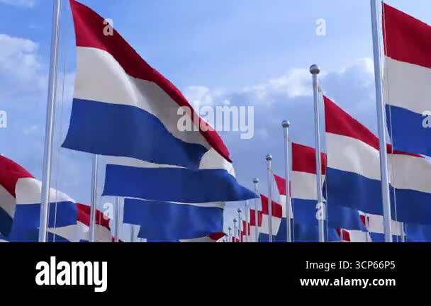 The Netherlands national flags waving against a blue sky, symbolizing ...