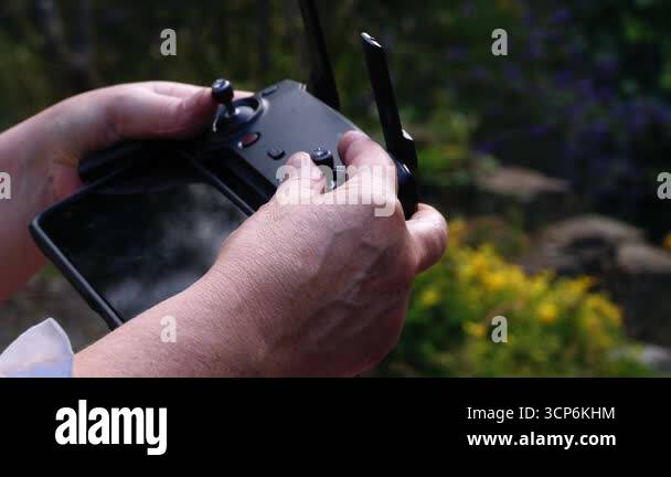Hands with drone and remote controller in background close up zoom shot ...