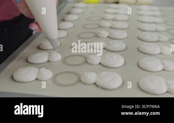 Close-up view of a pastry chef skillfully piping batter for macarons ...