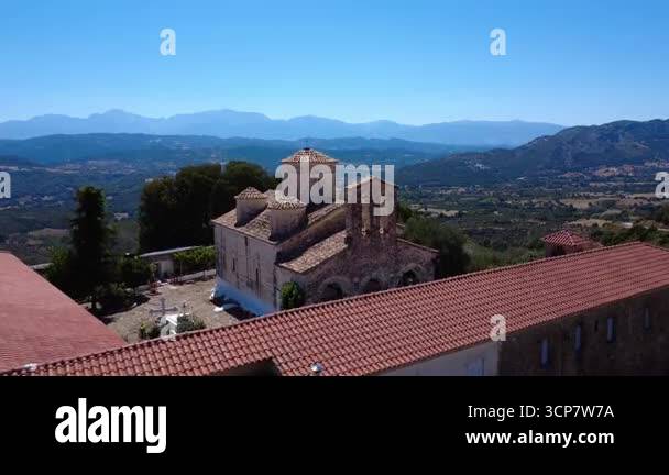 A Byzantine stone church in Greece stands on a hillside with domes and ...