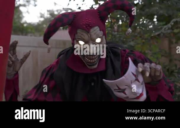 Close-up scary jester Halloween decoration with glowing eyes and a ...