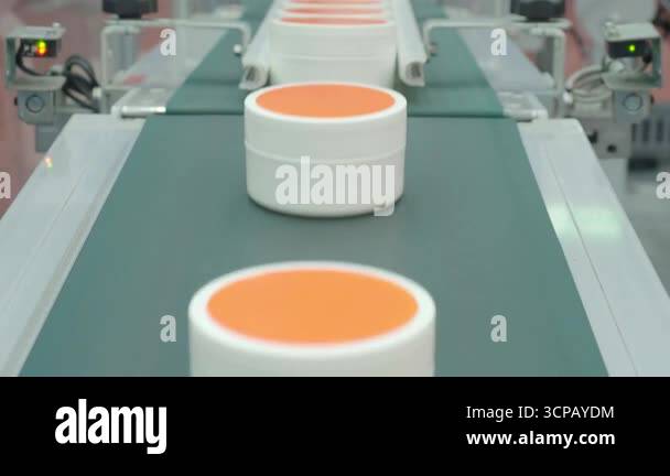 Demo making of Cosmetic cream jars move along automated conveyor belt ...